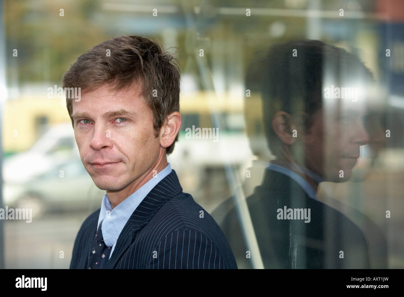 Man leaning against glass wall outdoors in city Stock Photo - Alamy