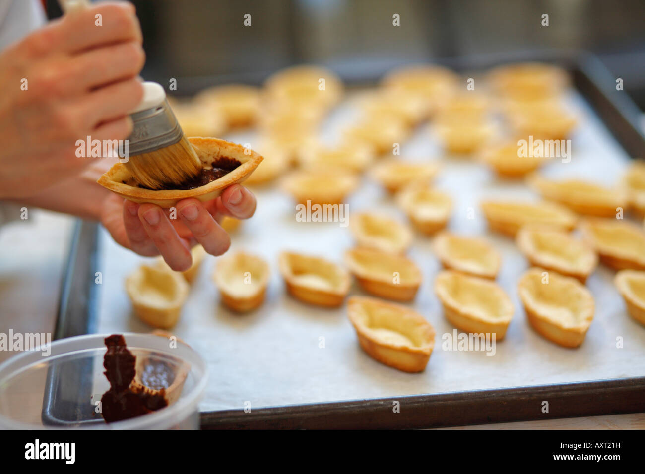 Filling pastry boats with chocolate Stock Photo - Alamy