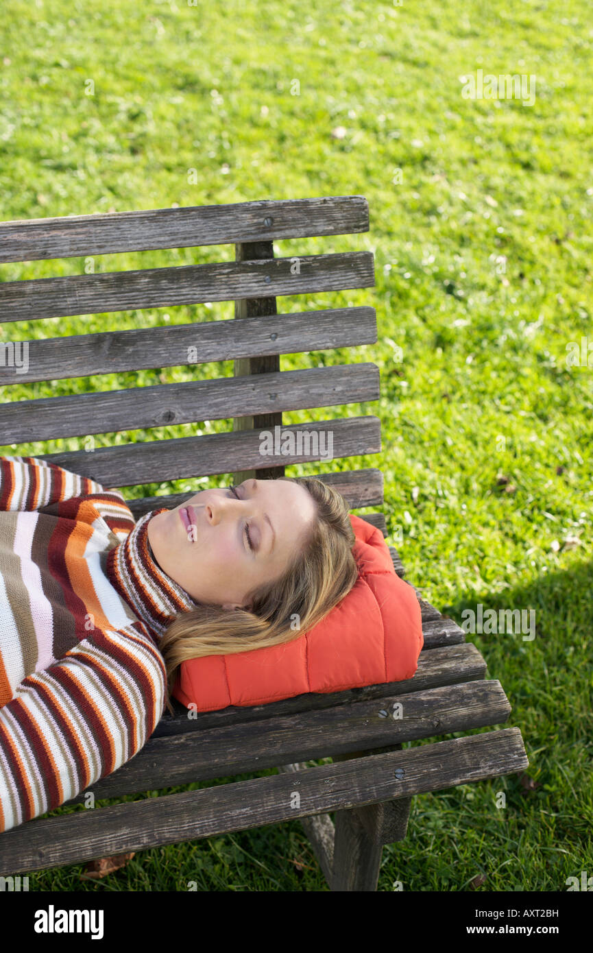 Young woman lying dozing on a wooden bench, high angle view Stock Photo ...