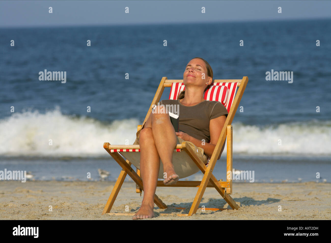 Woman sitting on a beach chair Stock Photo - Alamy