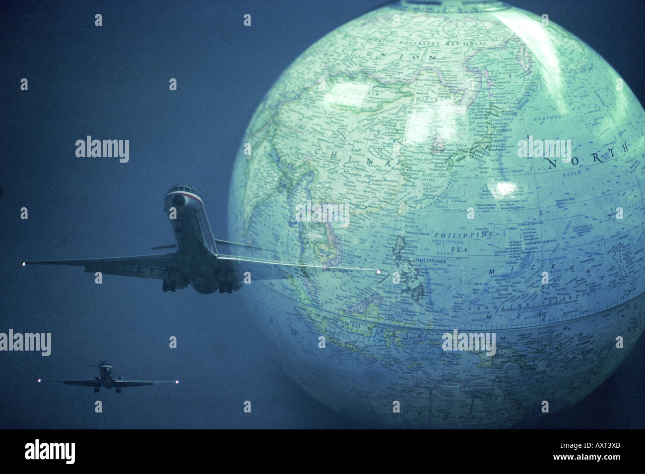 Airplanes circling globe symbolizing world travel Stock Photo - Alamy