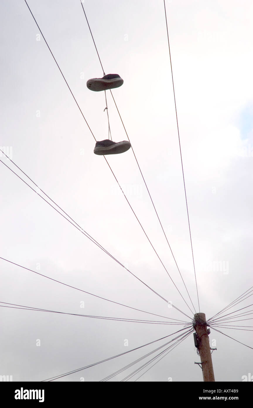 Trainers hanging from a telephone wire Stock Photo - Alamy