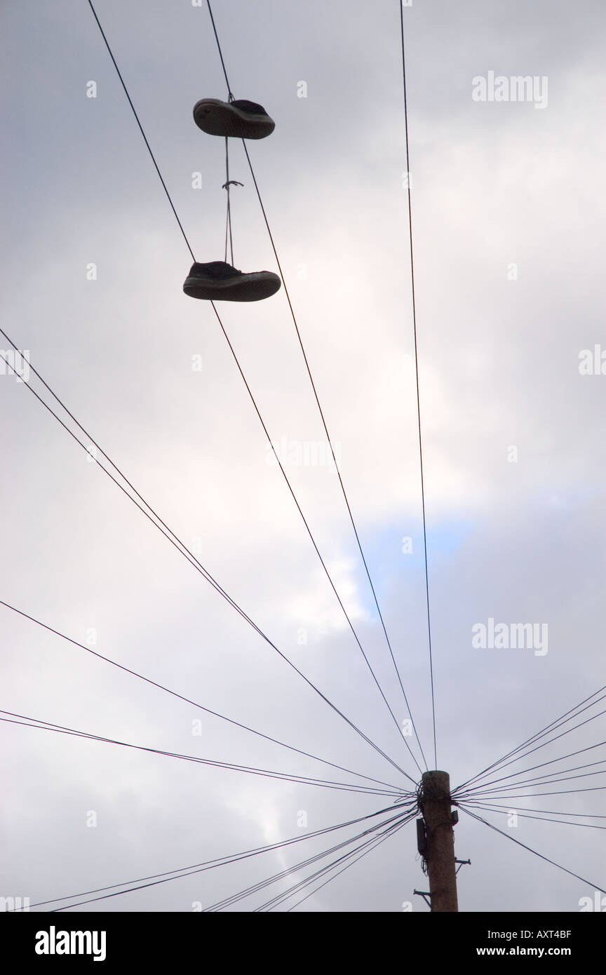 Trainers hanging from a telephone wire Stock Photo - Alamy