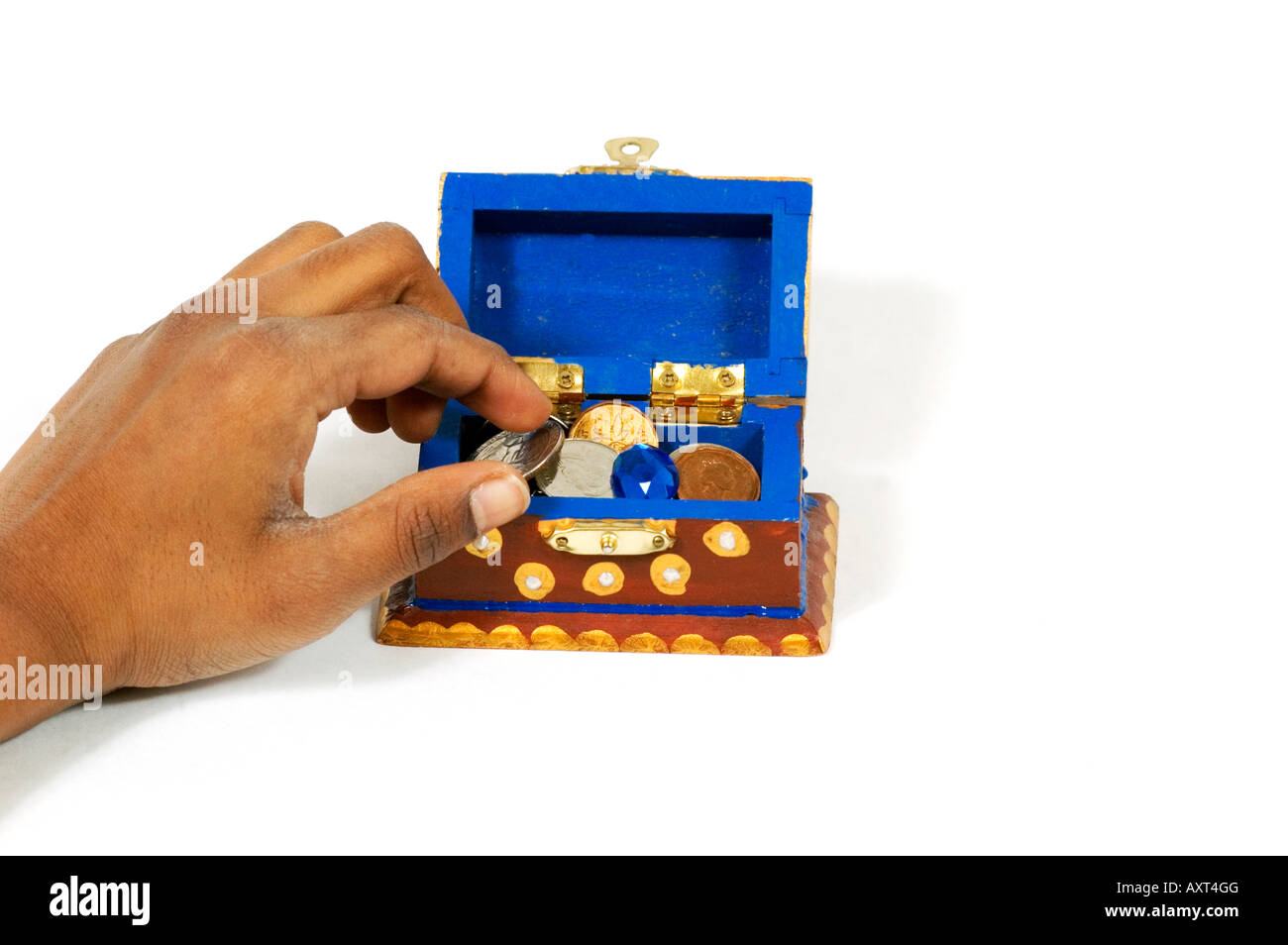 A child takes a coin from a toy treasure chest The treasure chest is ...