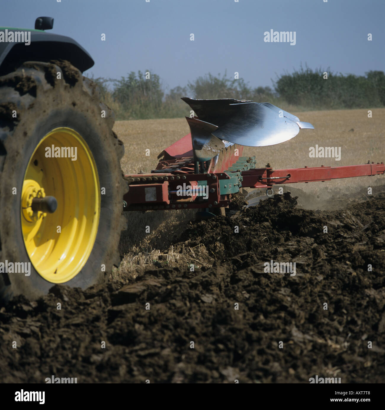 Tractor with seven coulter reversible plough ploughing a cereal stubble ...