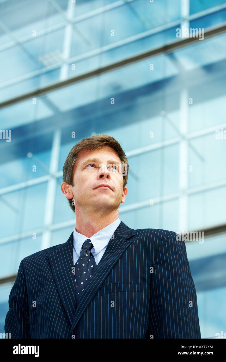 Man outside office building looking up Stock Photo - Alamy