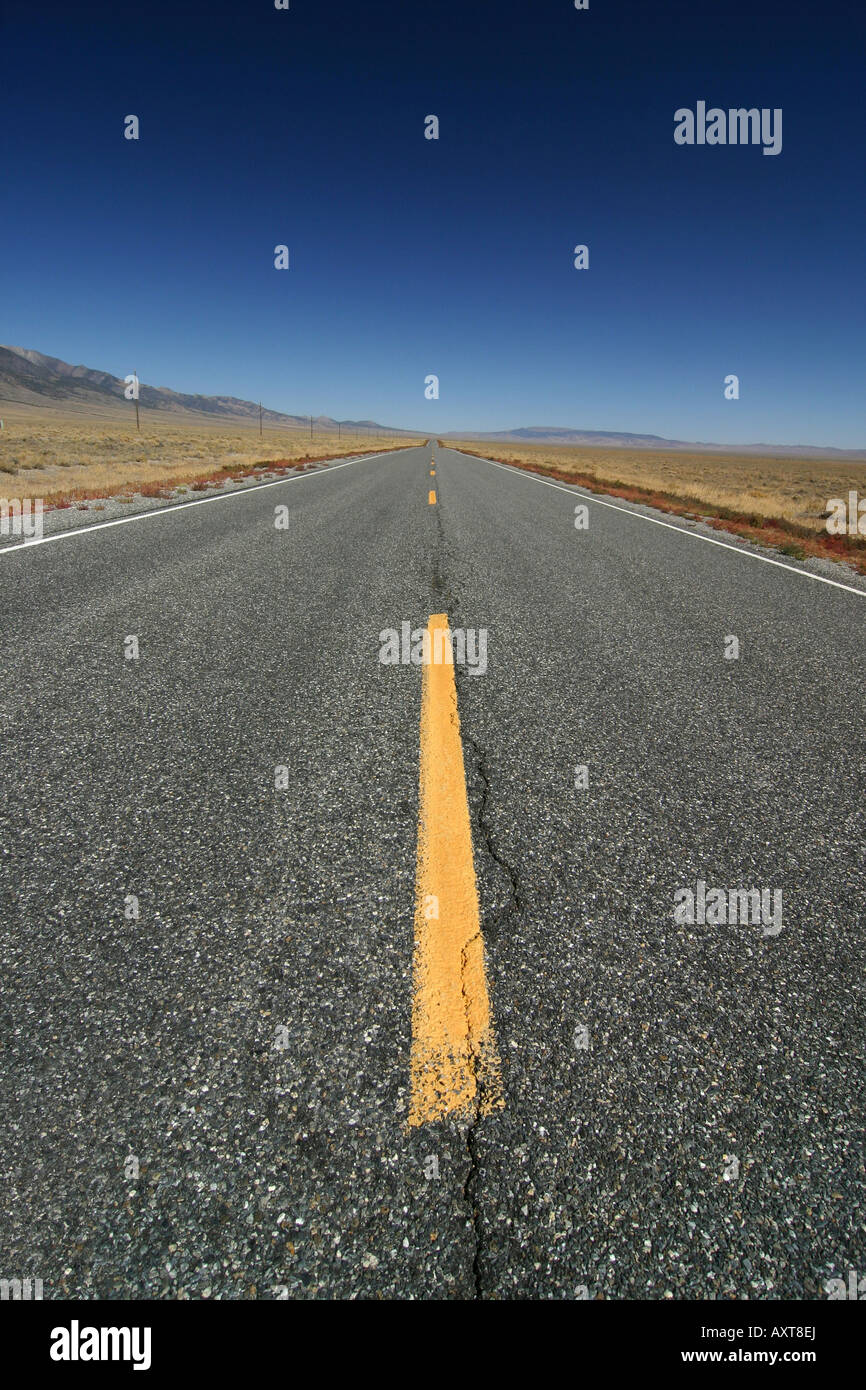Road in central Nevada stretches to the horizon, view close to the ...