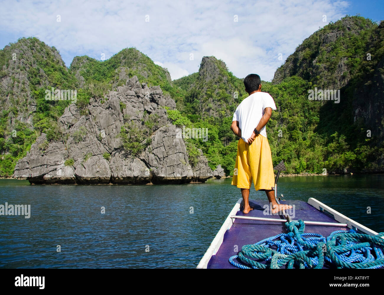 An outriggered boat closes in to an island rock surface formation in ...