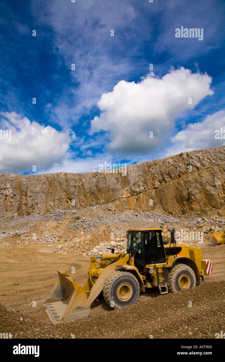 Large bulldozer in a quarry with blue sky and fluffy clouds Stock Photo ...