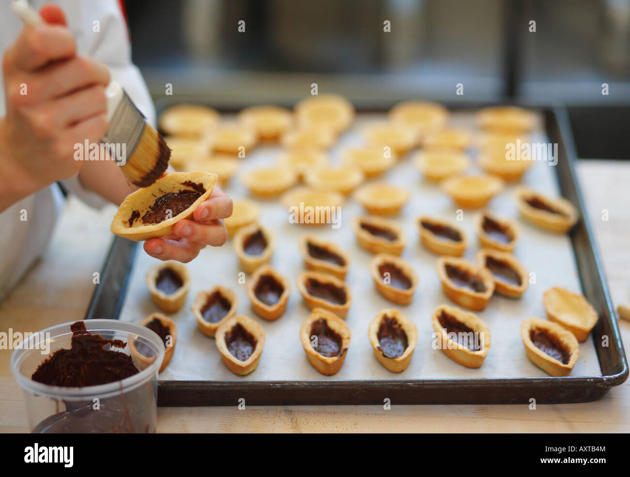 Filling pastry boats with chocolate Stock Photo - Alamy
