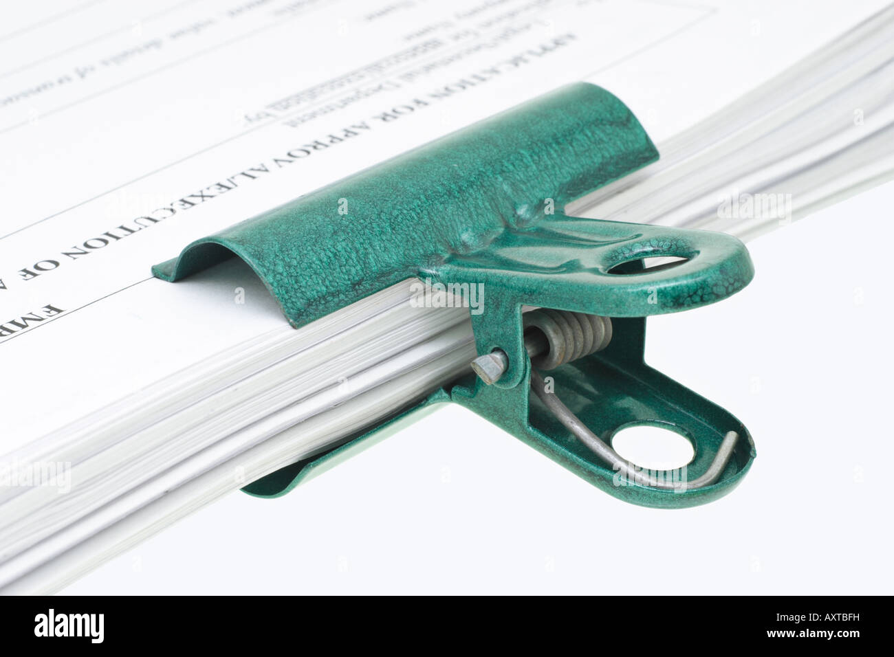 Green paper clip holding a stack of documents Stock Photo - Alamy