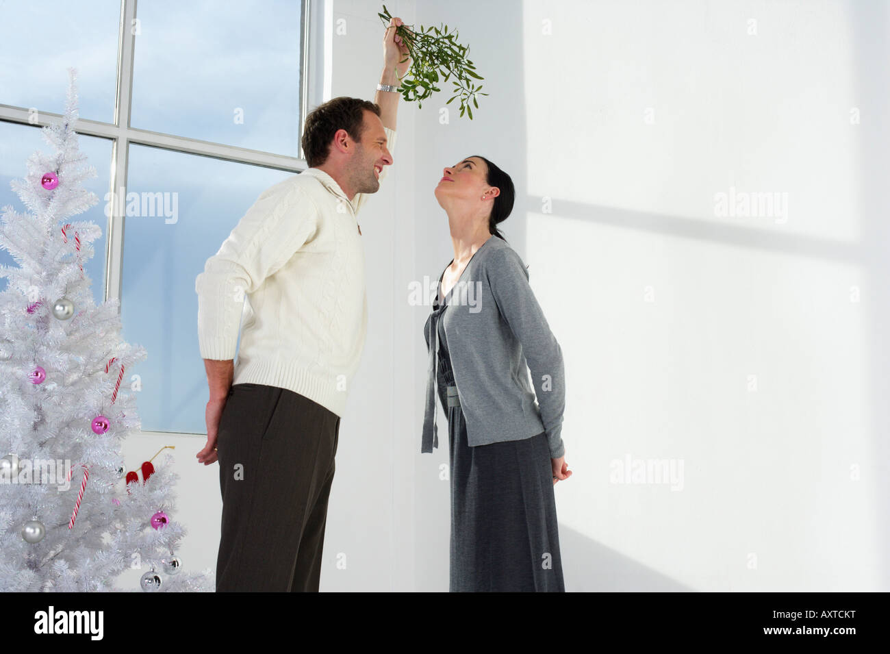 Couple standing under a mistletoe Stock Photo - Alamy