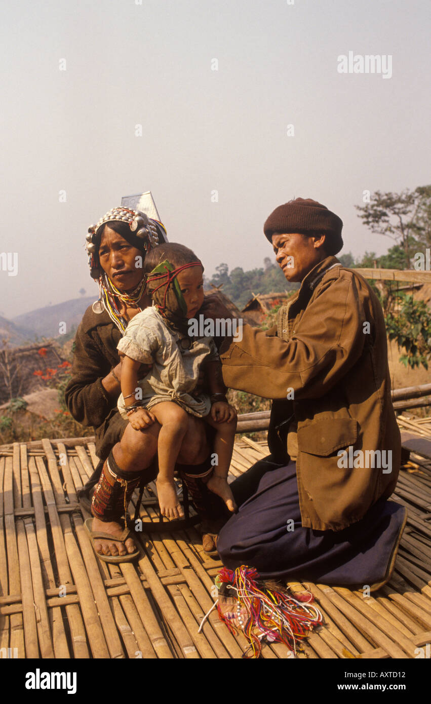 Medicine man applies natural poultice to childs face. Akha village Pala ...