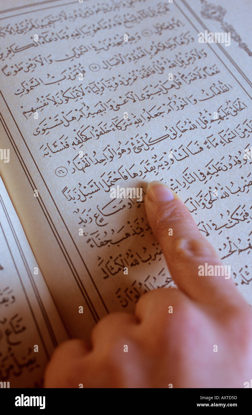 Finger pointing to arabic script in the Koran Stock Photo - Alamy