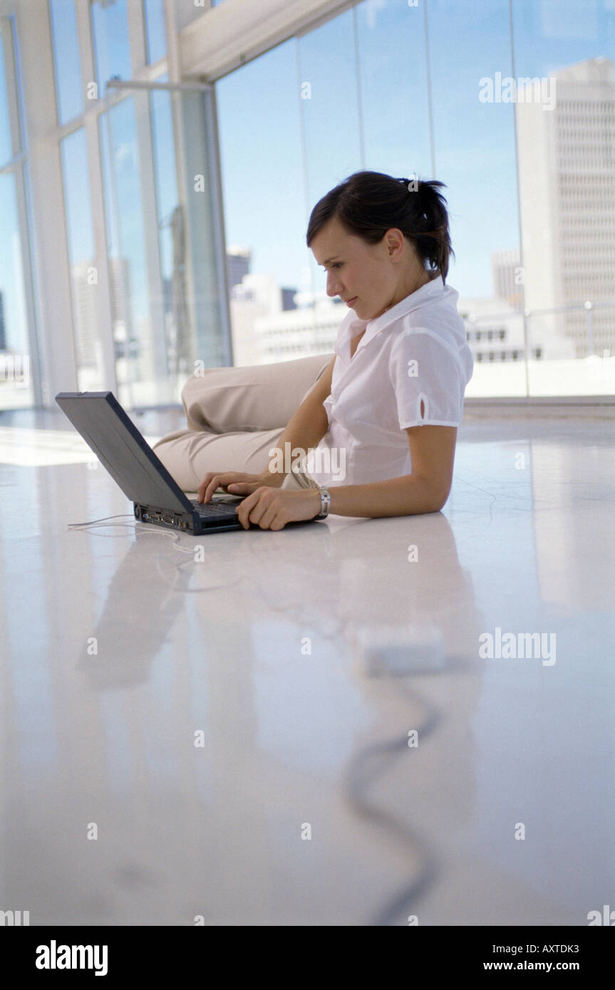 Young woman lying on the floor and using a laptop Stock Photo - Alamy