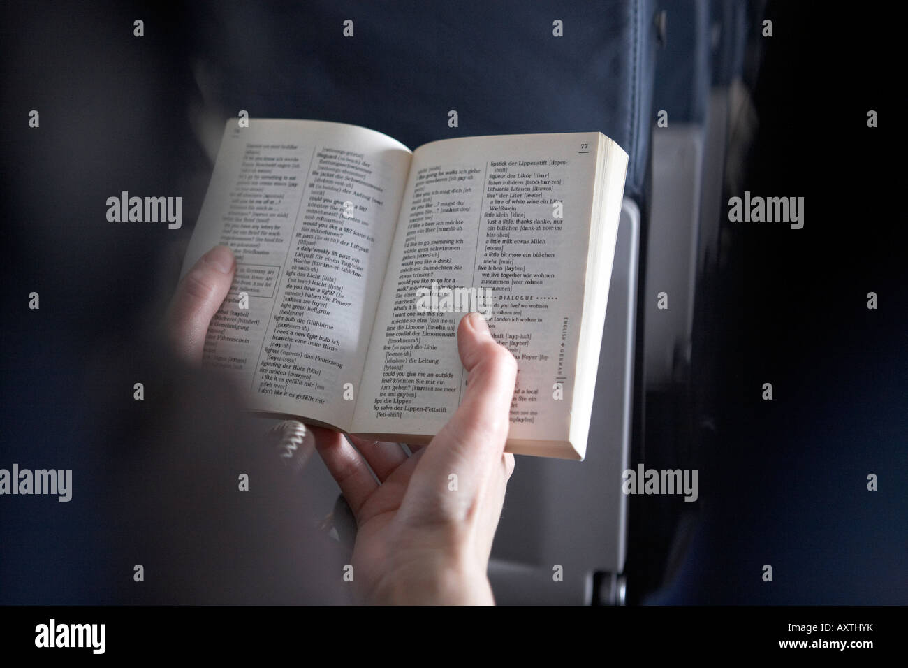 Airline passenger reading a book Stock Photo - Alamy