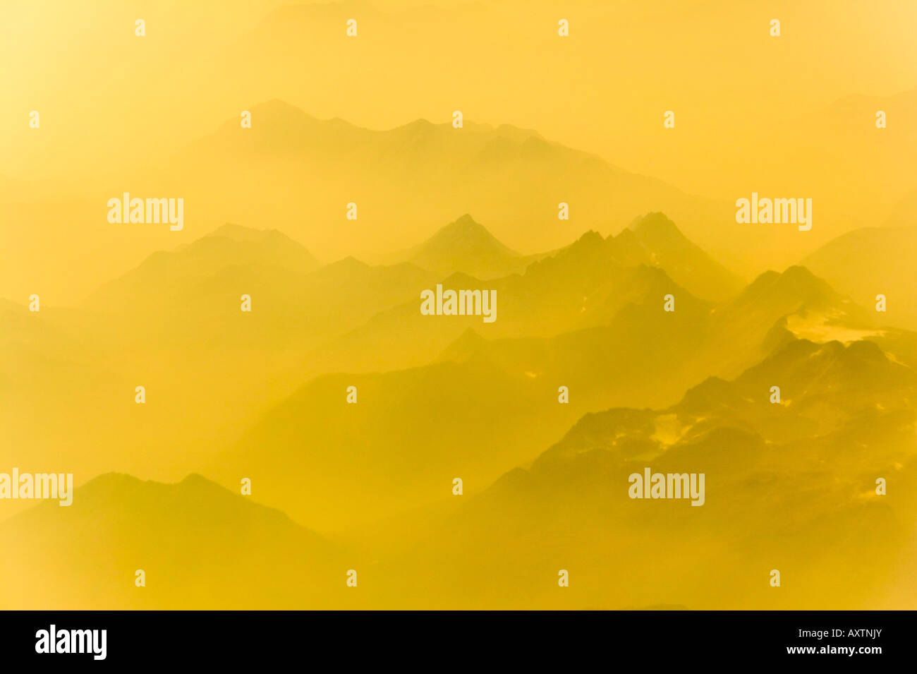 Aerial view of smoke filled mountain peaks with yellow color tone ...