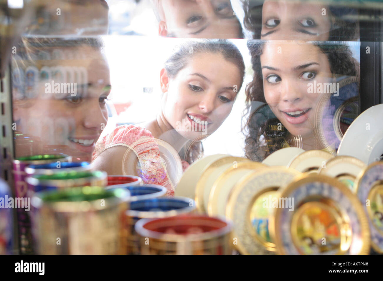 Three young women looking in a store window Stock Photo - Alamy