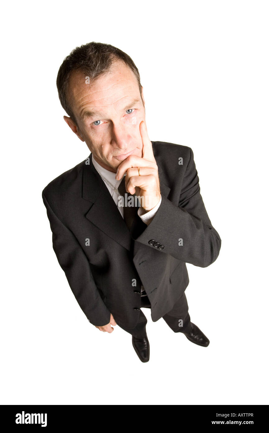 Business man standing in a black suit with a finger on his face ...