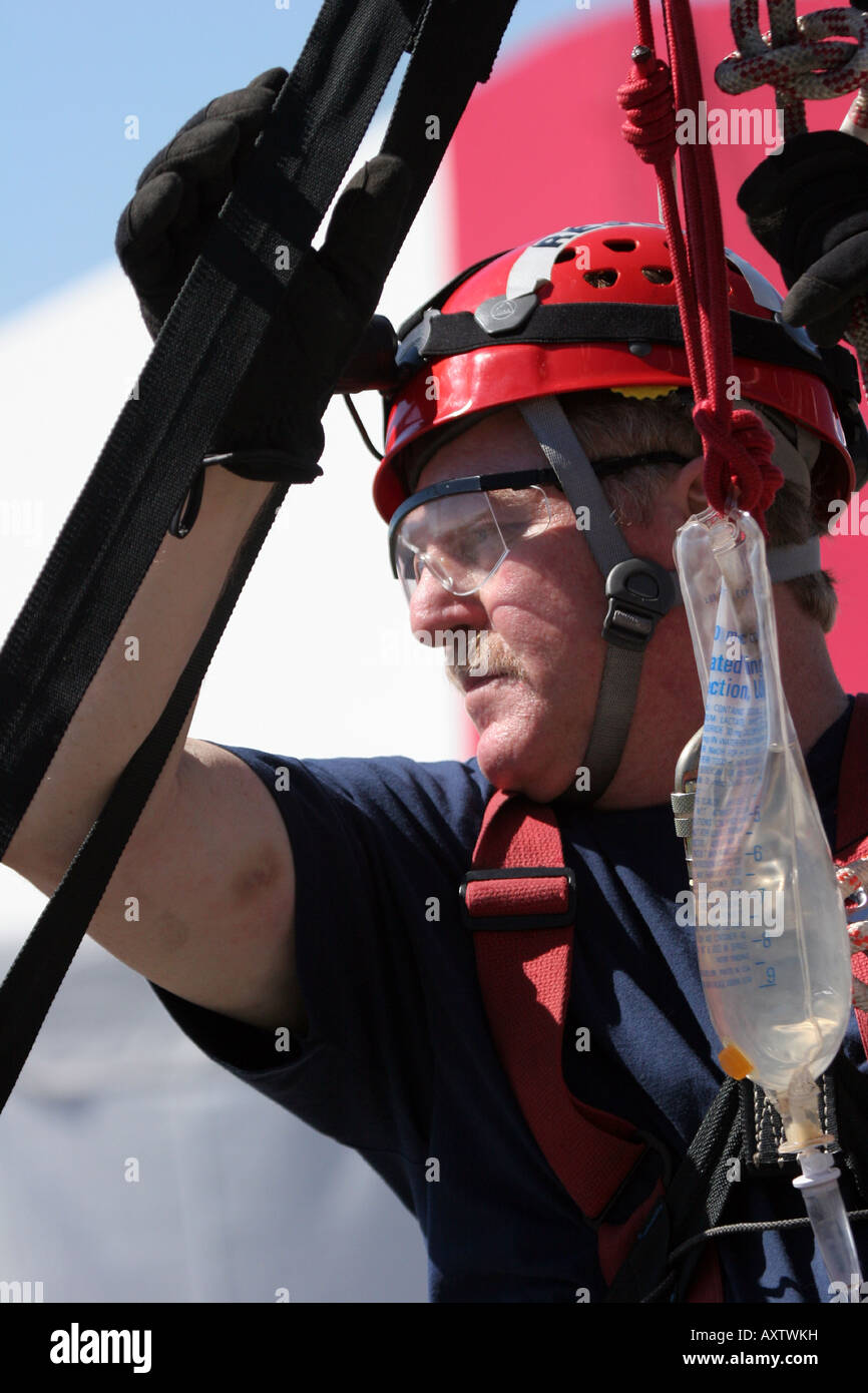 A EMS medical personnel riding the aerial basket with a saline bag for ...