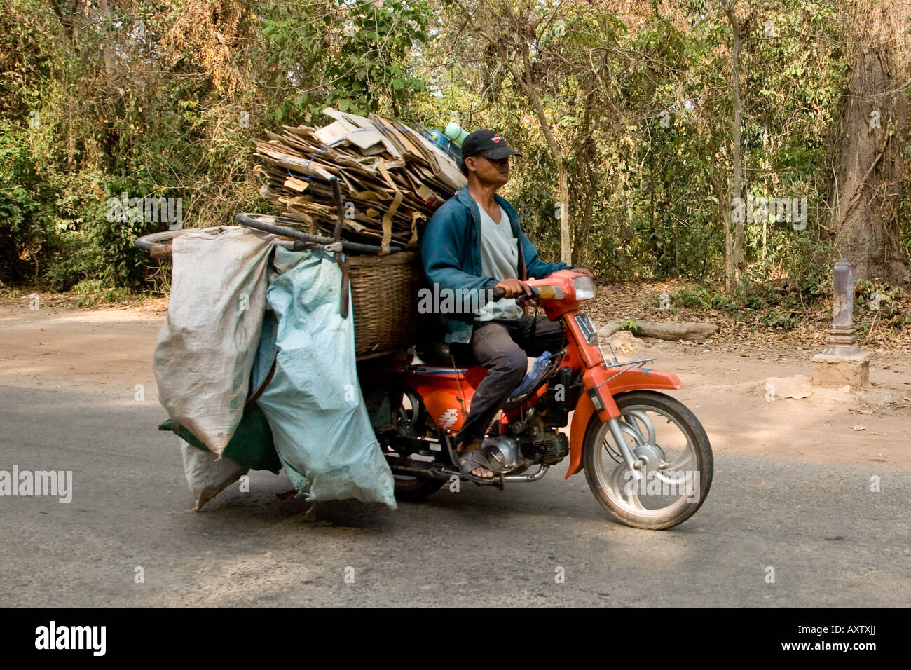 A man carries a huge load of wood on the back of a motorcycle Stock ...
