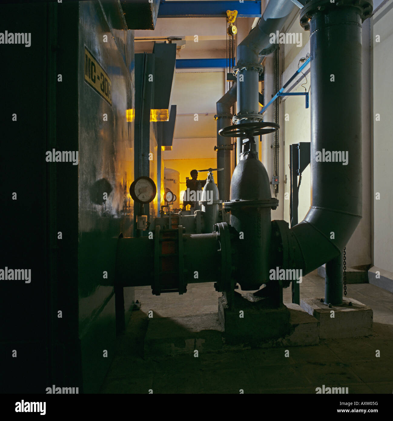 Operator adjusting water flow by turning valve inside water treatment ...