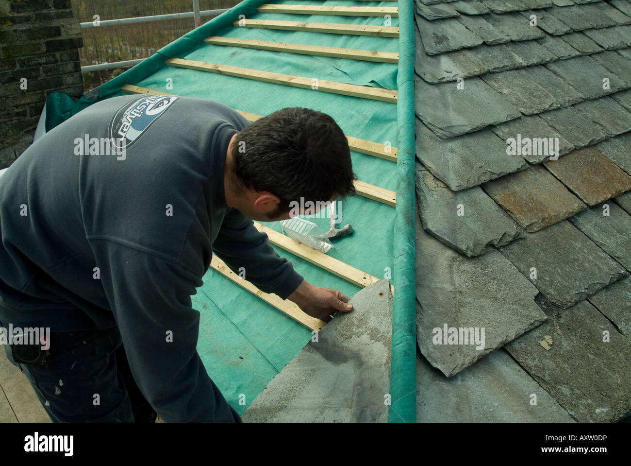 Man tiling with traditional roof with slate roof tiles Stock Photo - Alamy