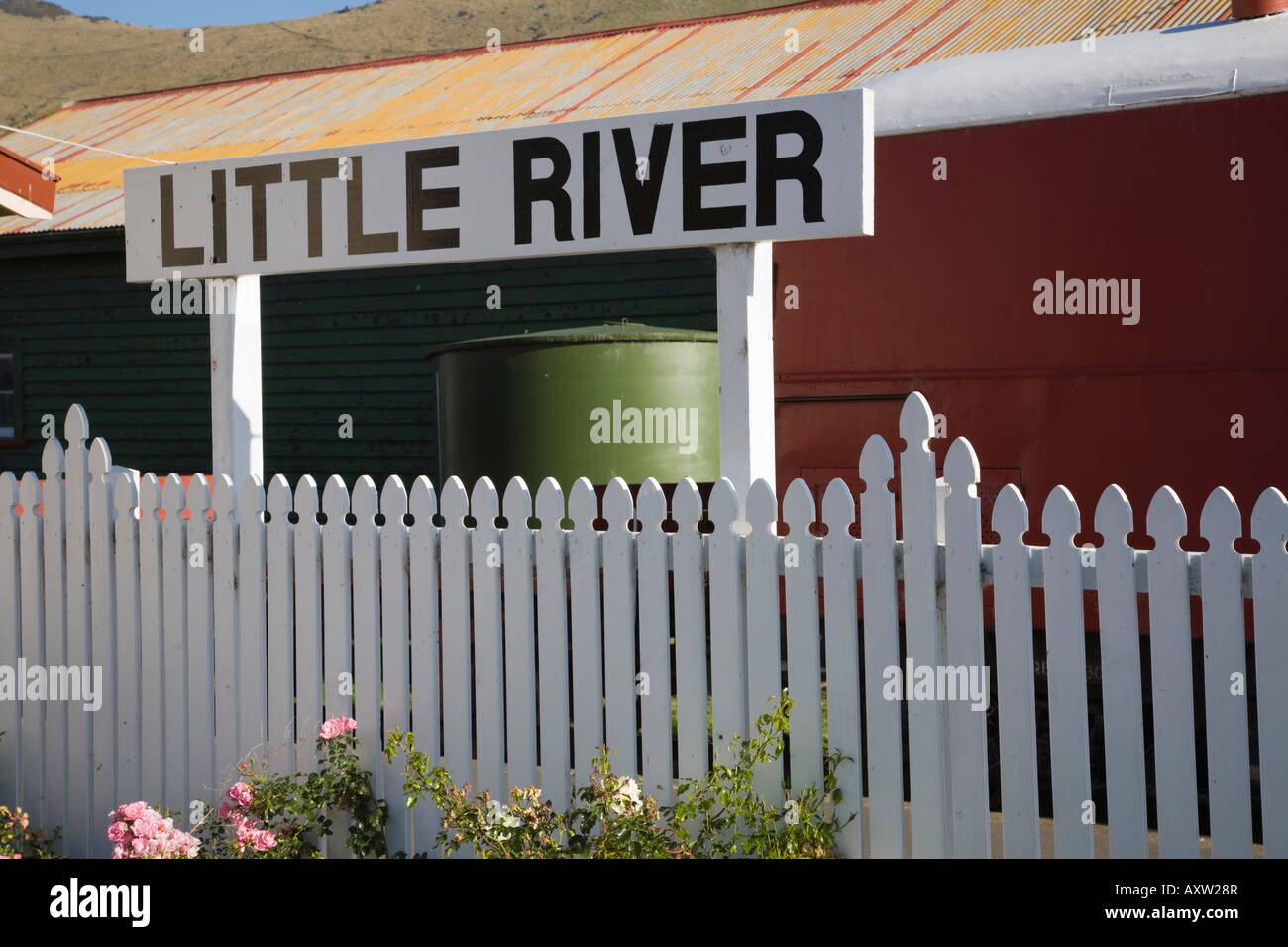 Village place name sign on white wooden picket fence outside old ...
