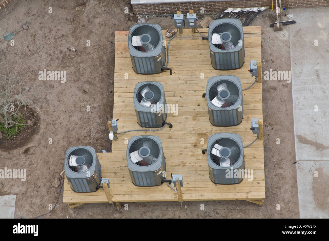 Seven air conditioning units on a wooden platform at a construction ...