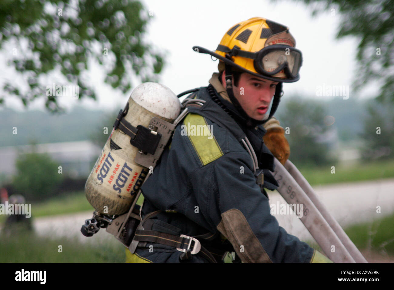 A firefighter pulling the hoseline at an emergency fire scene Stock ...