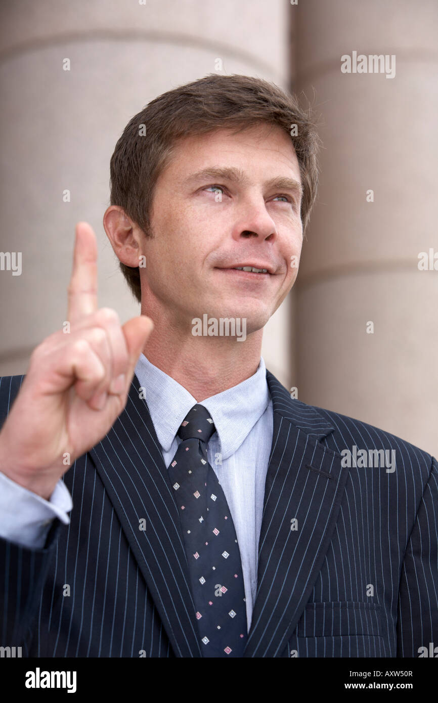 Man pointing up with index finger outside building Stock Photo - Alamy