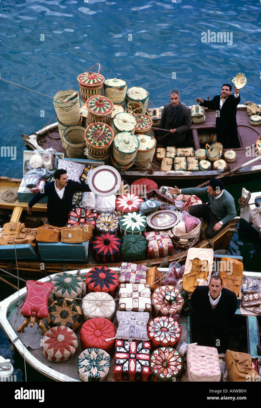 Arab vendors selling goods from small bumboats to a visiting ship in ...