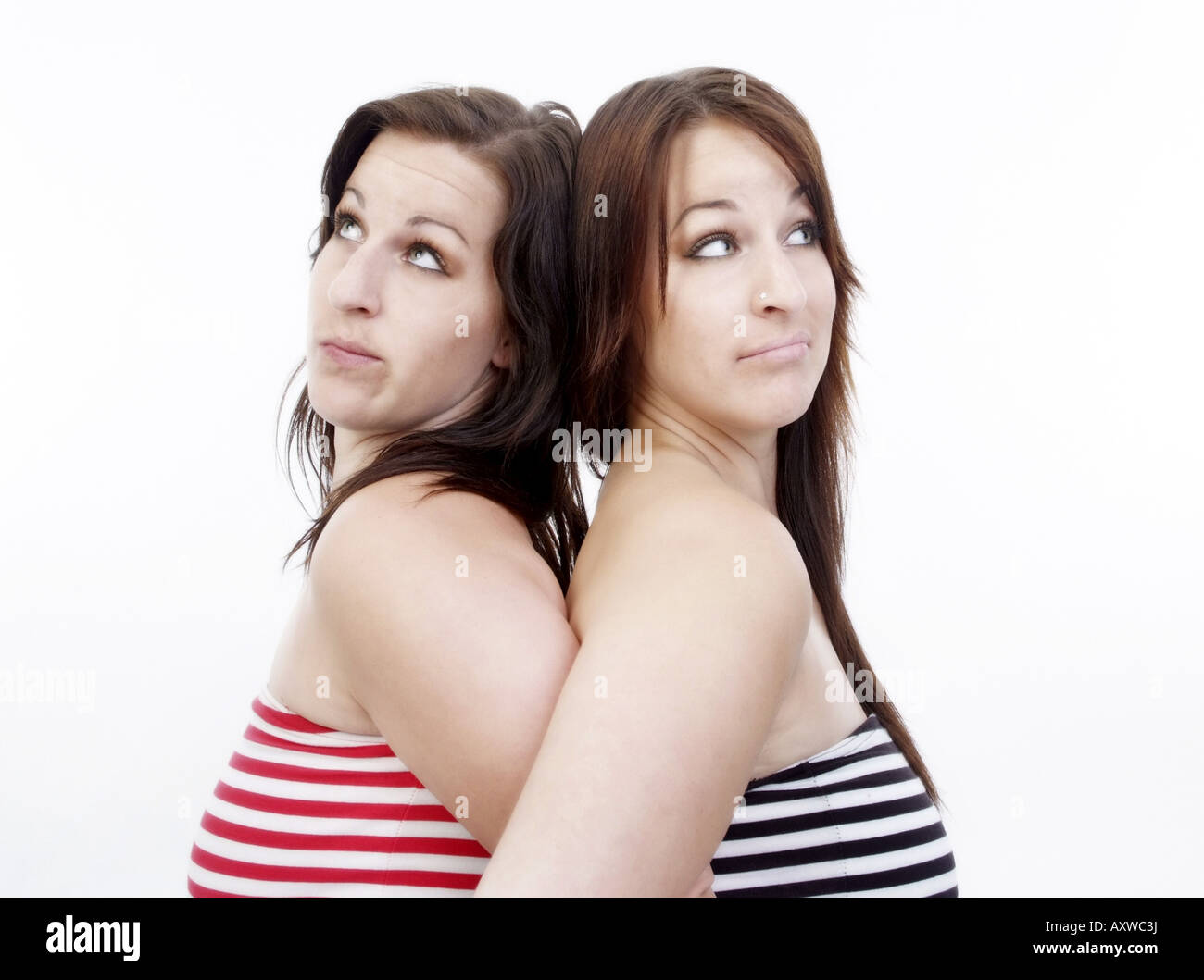 twin sisters in striped tops, with sceptical view Stock Photo - Alamy