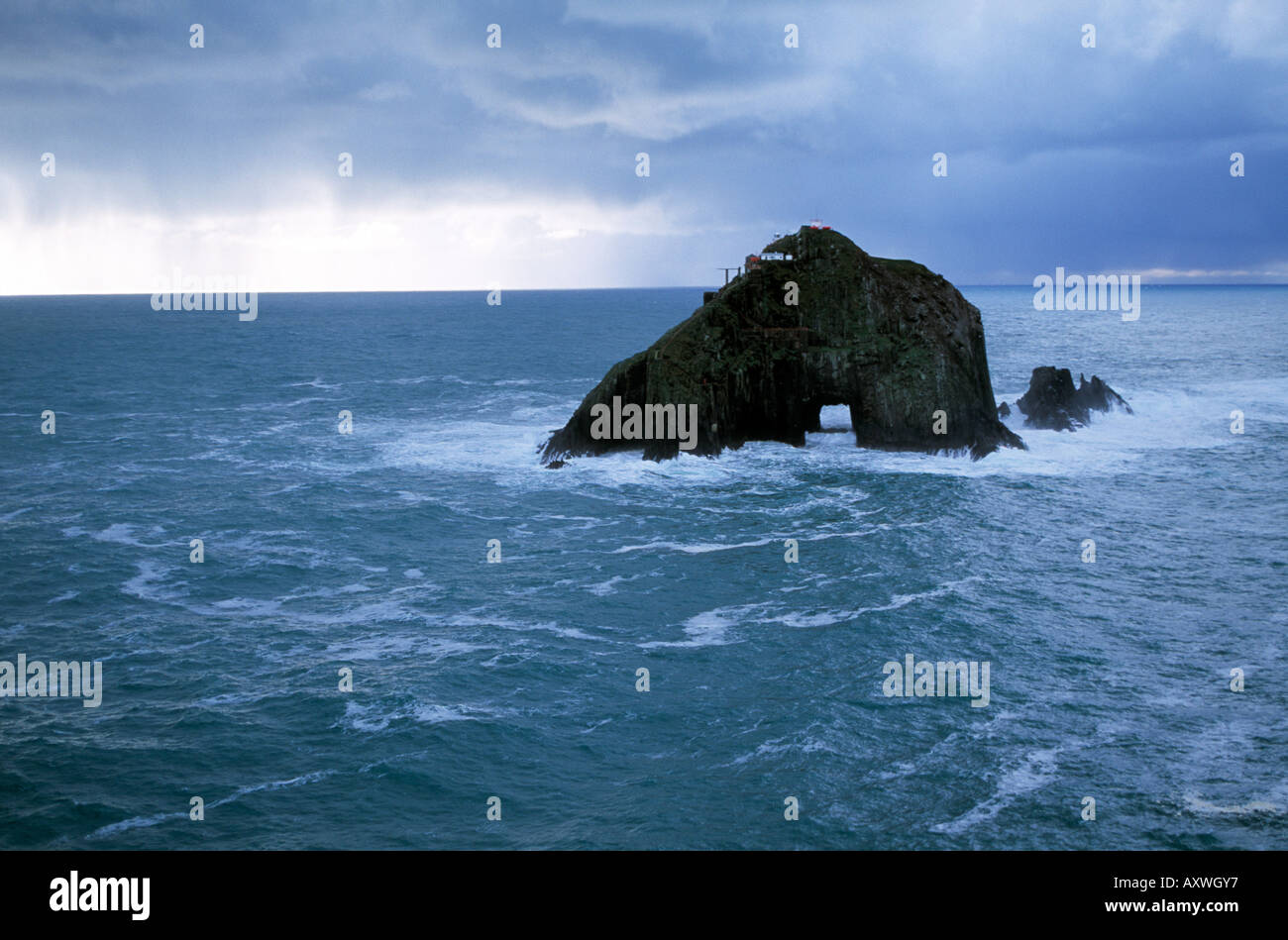 inaccessible steep rock island with lighthouse in the wild atlantic sea ...