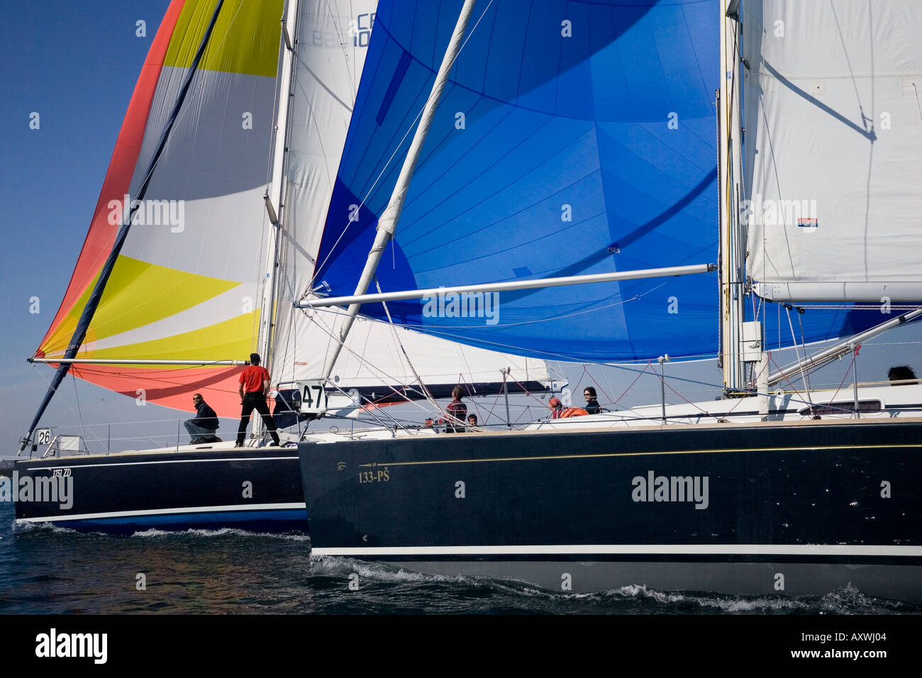 Two cruiser sailing boats racing each other downwind, with main sails ...