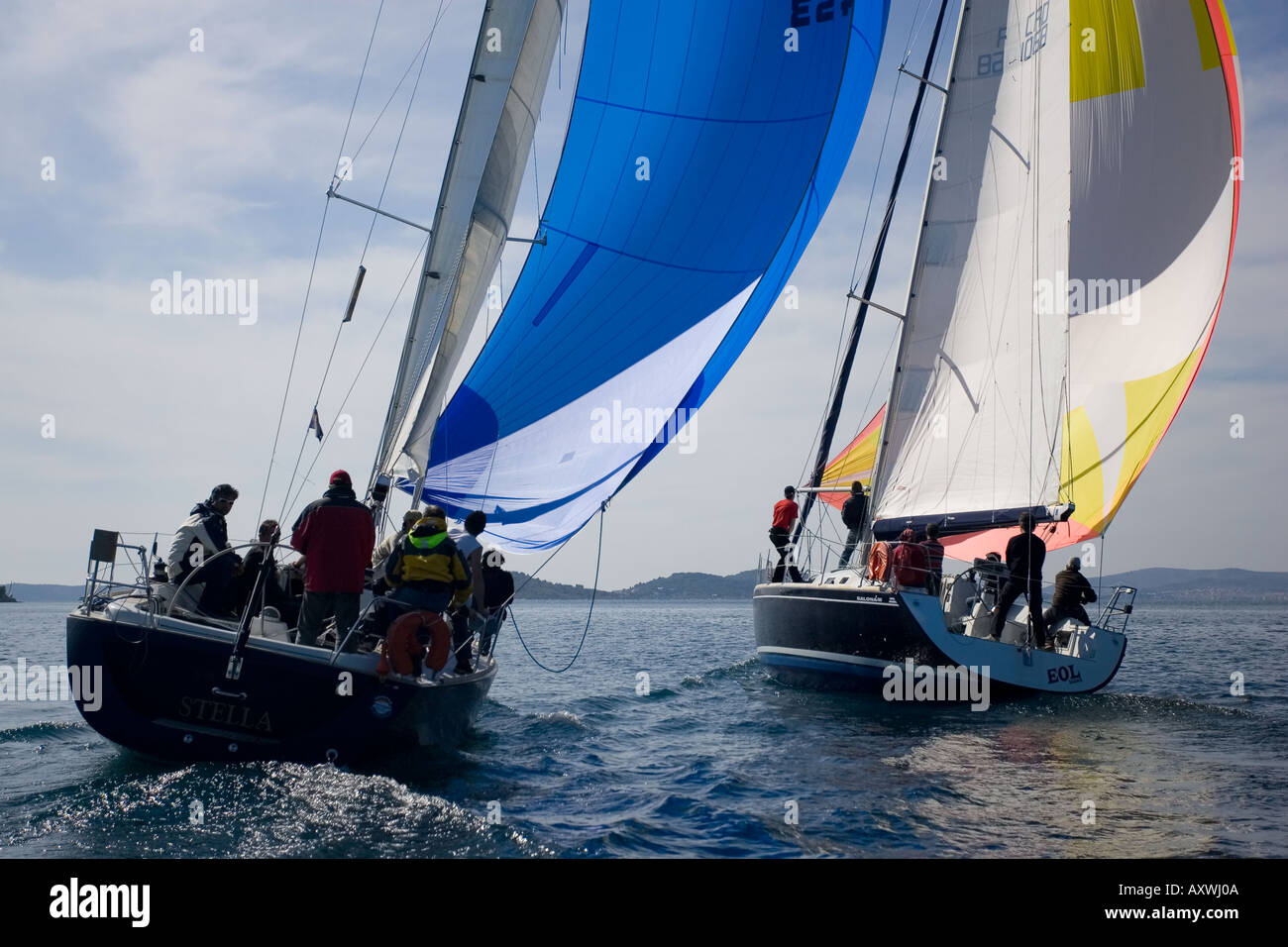 Two cruiser sailing boats racing each other downwind, with main sails ...