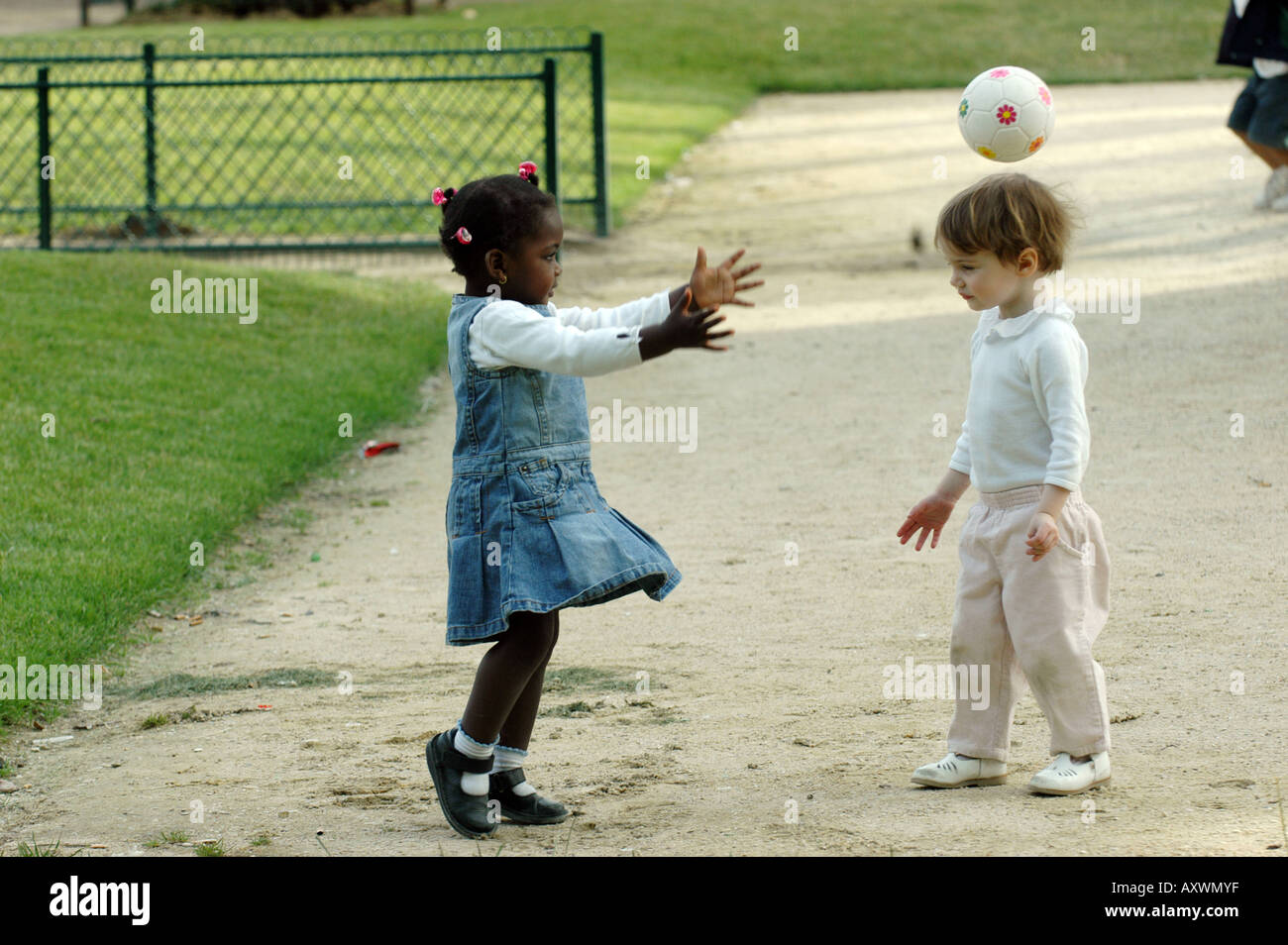 Two children play ball in a park in Paris near the Eiffel Tower Stock ...