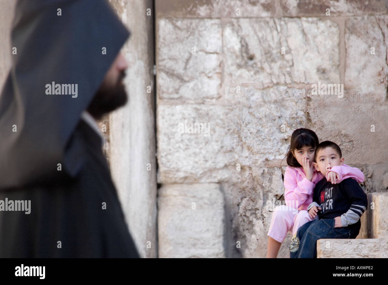 Boy and girl stare in awe at a black robed Armenian priest Stock Photo ...