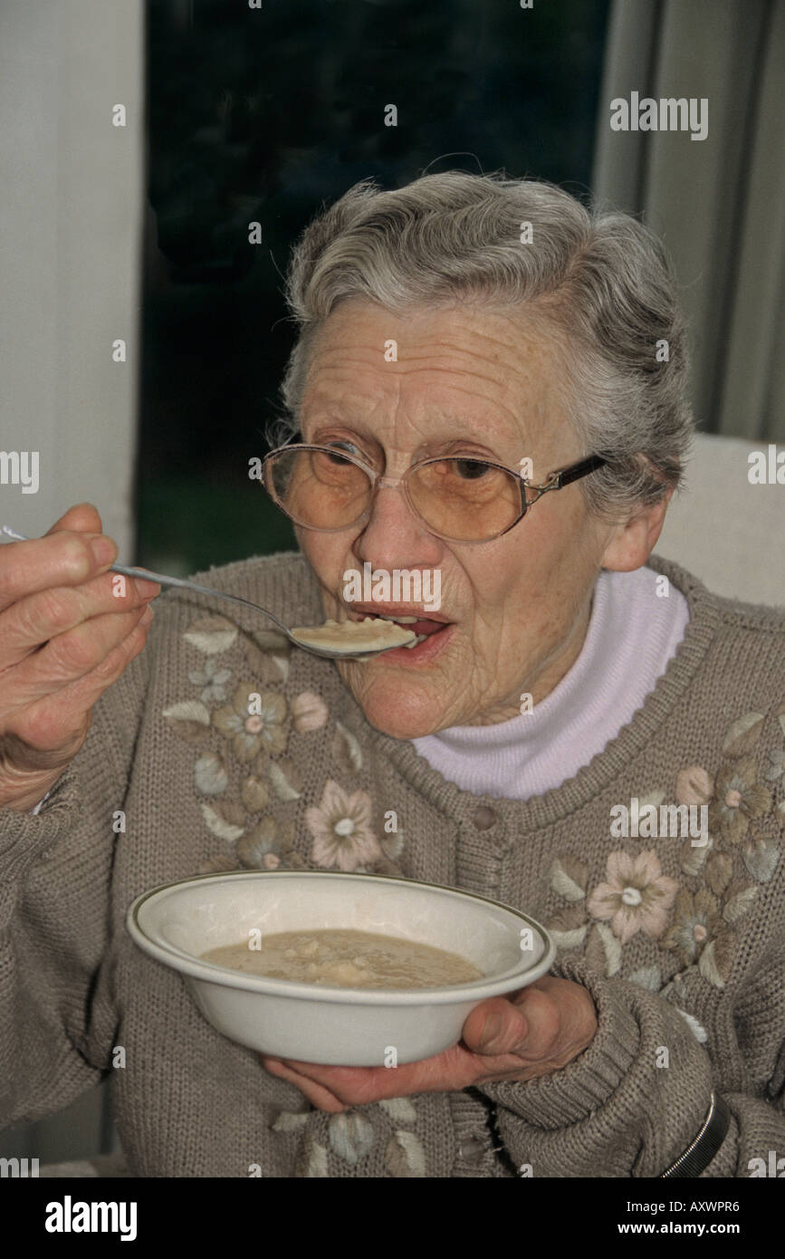 elderly woman eating rice pudding Stock Photo - Alamy