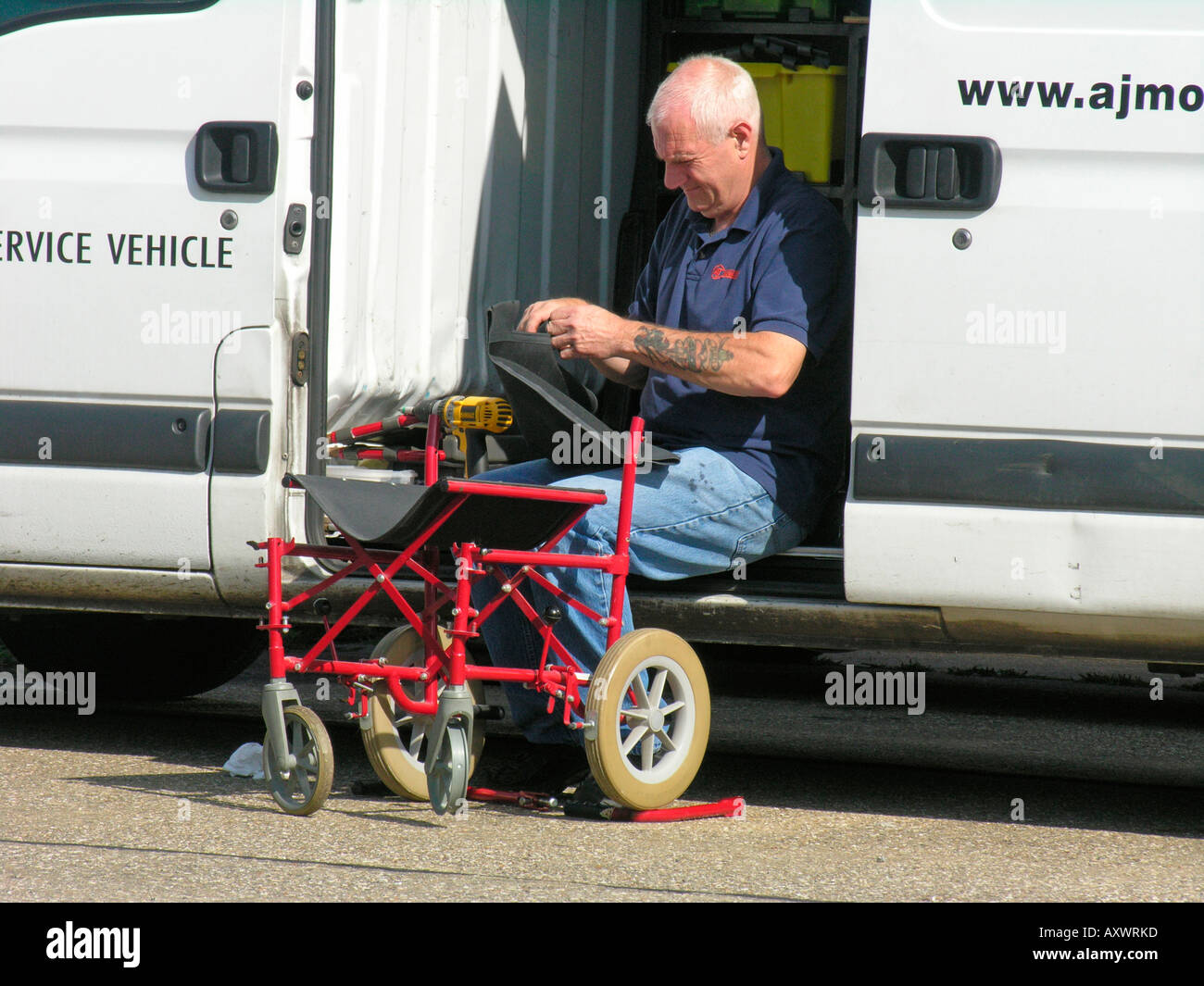 elderly man repairing and mending a wheelchair from a wheelchair ...