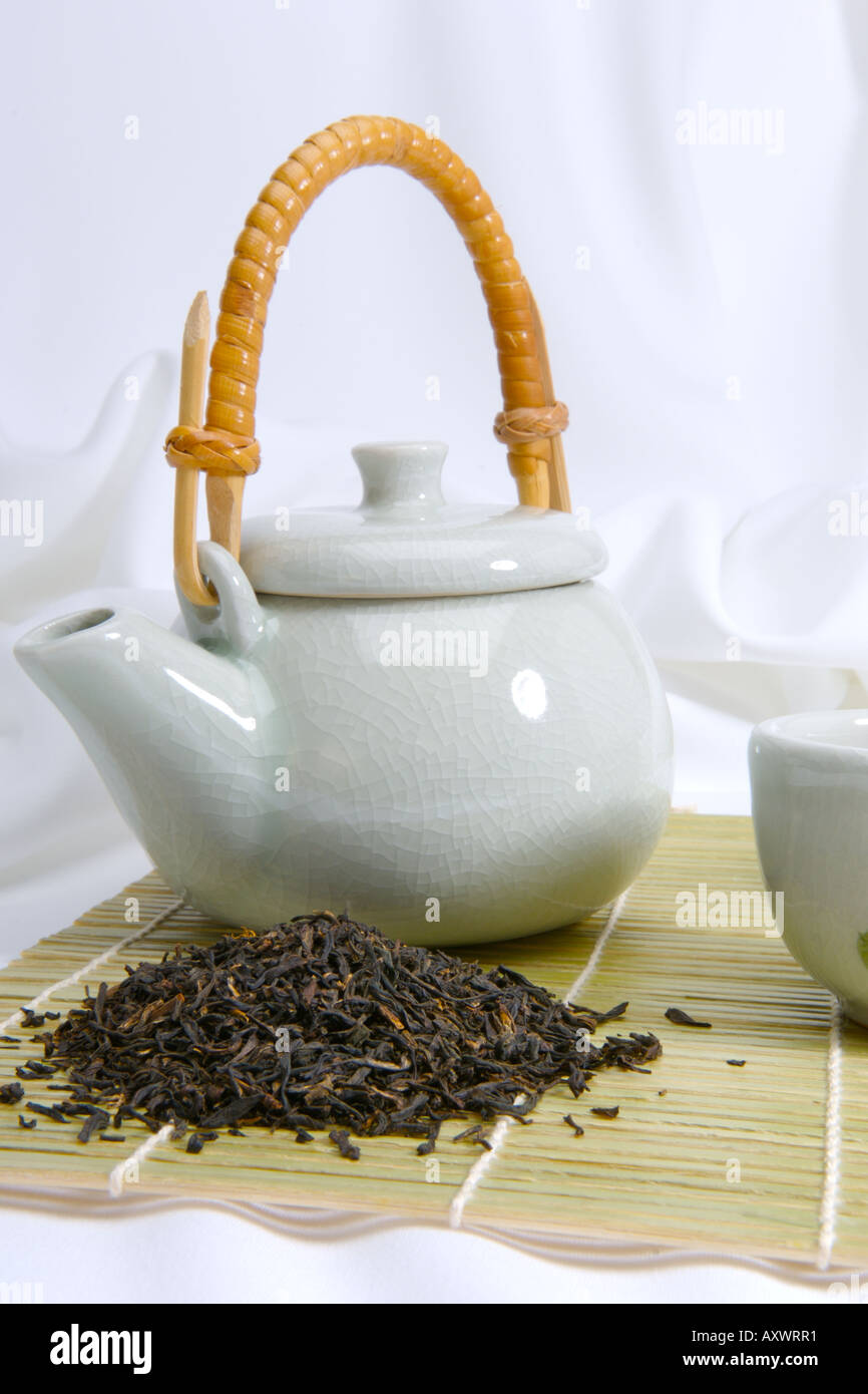 Green chinese teapot with tea cups and tea leaves ready to serve tea ...
