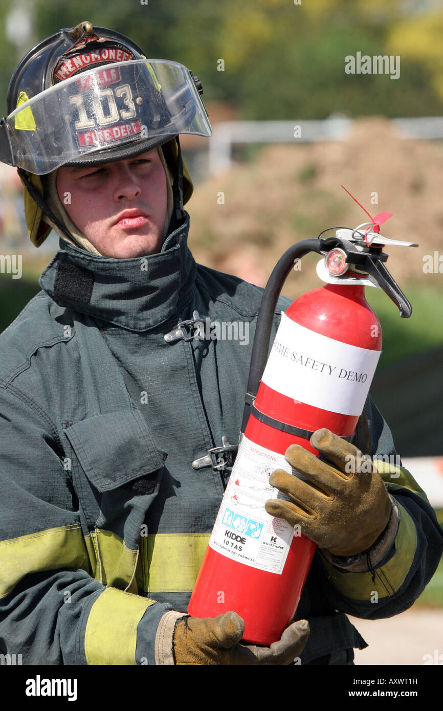 A firefighter holding an extinguisher that will be used in a ...