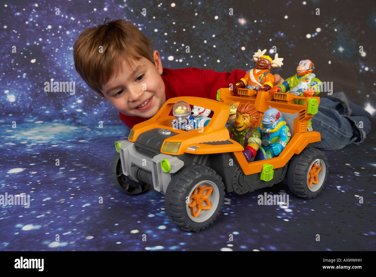 a boy plays with a jeep and animal action figures against a starry ...