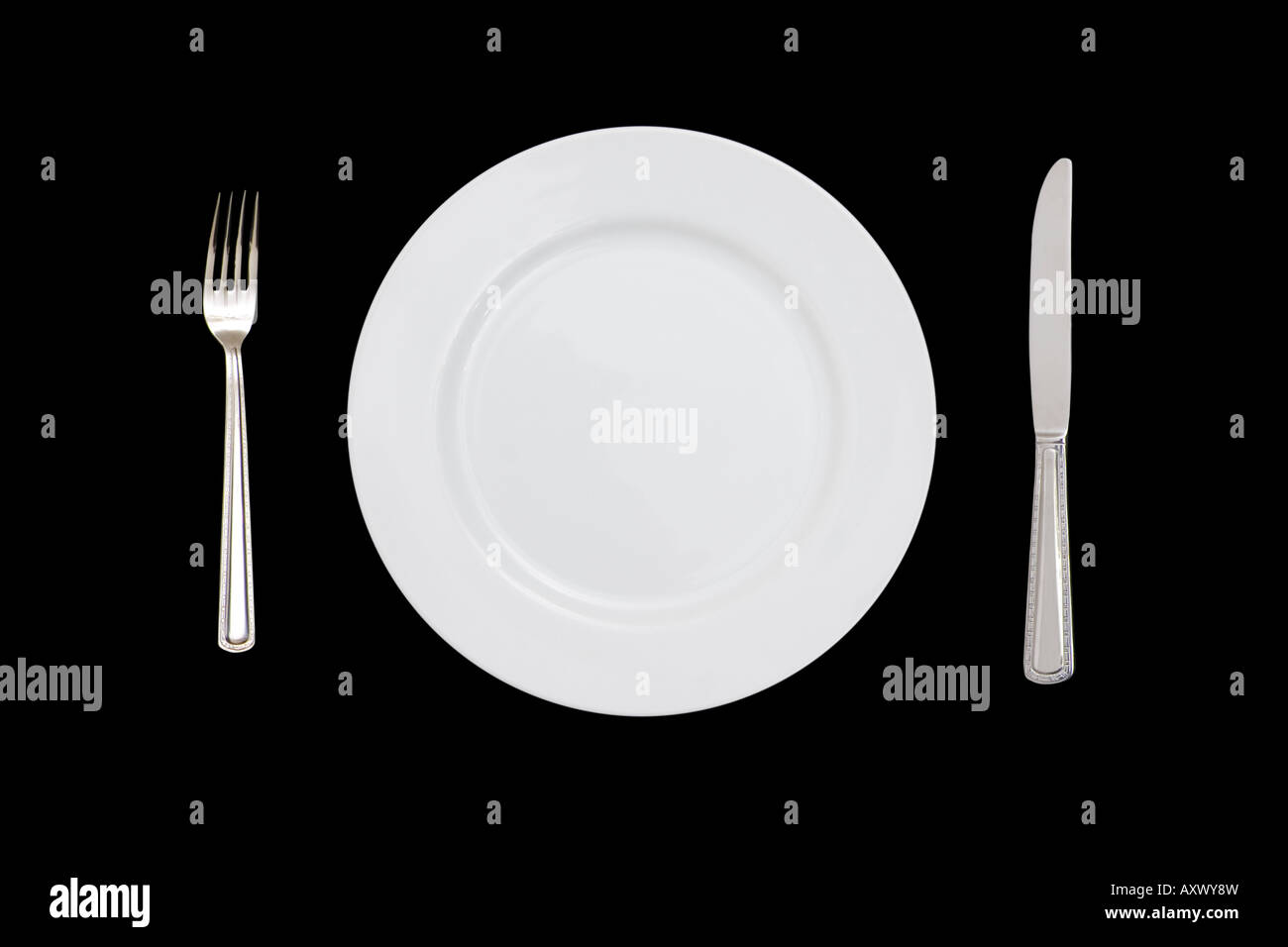 fork plate and knife isolated against black background Stock Photo - Alamy