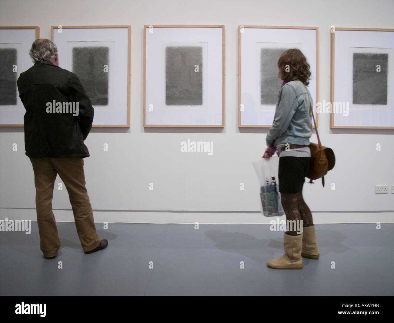 two people, man and woman, looking at artworks by Tim Davies artist ...