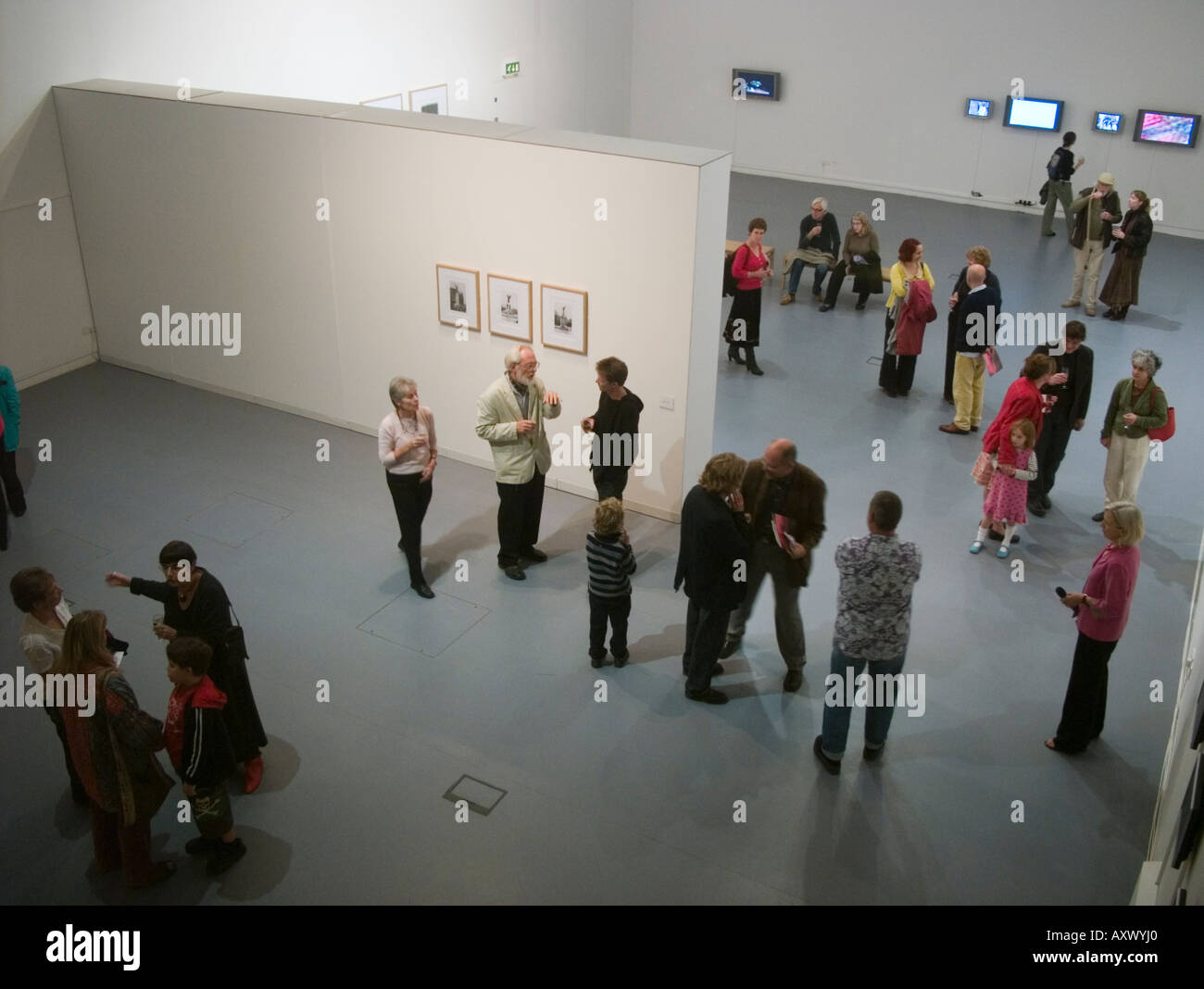 people in gallery looking at work by welsh artist Tim Davies exhibition ...