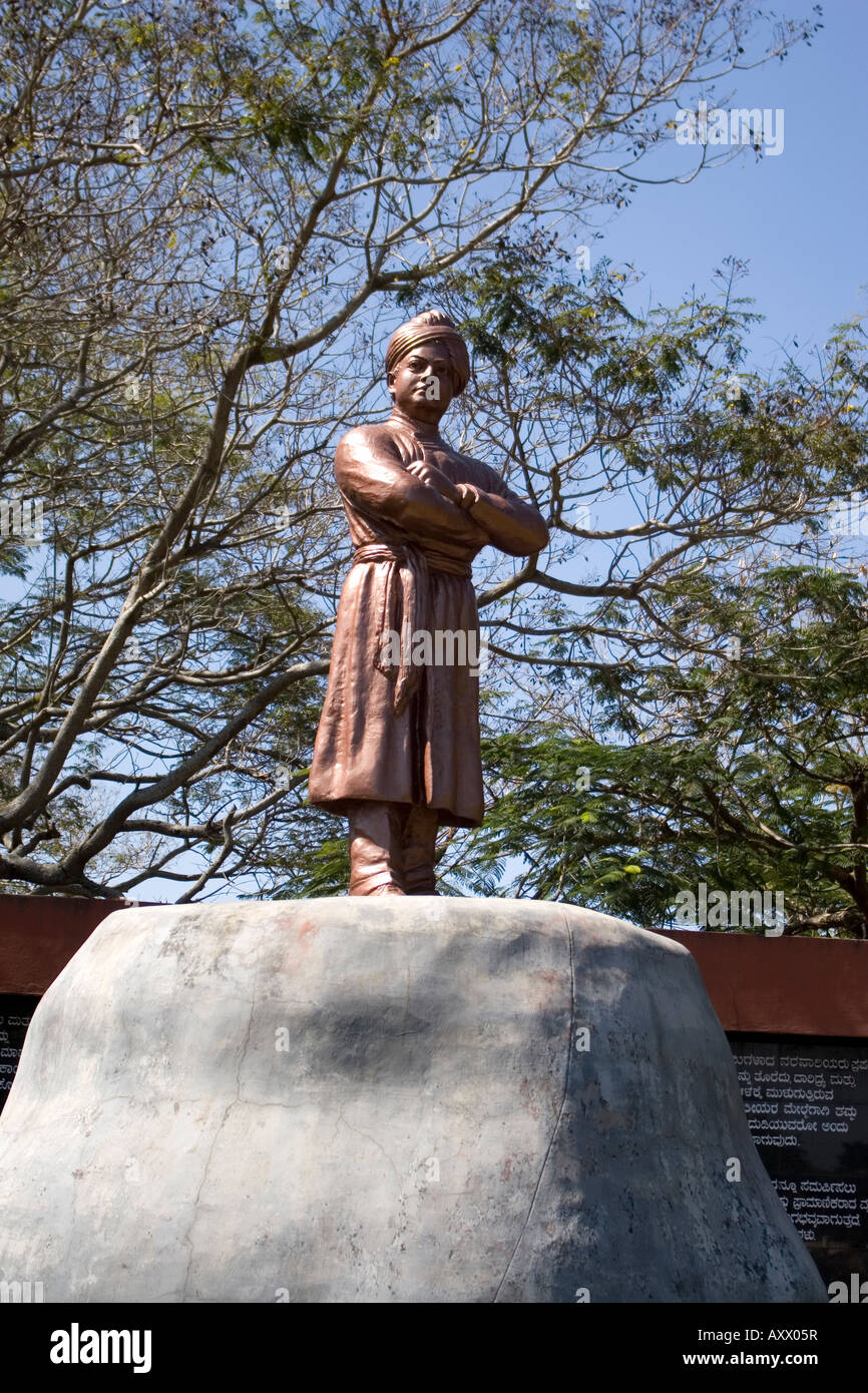 A statue of one of the Maharajas of Mysore stands arms folded on a rock ...