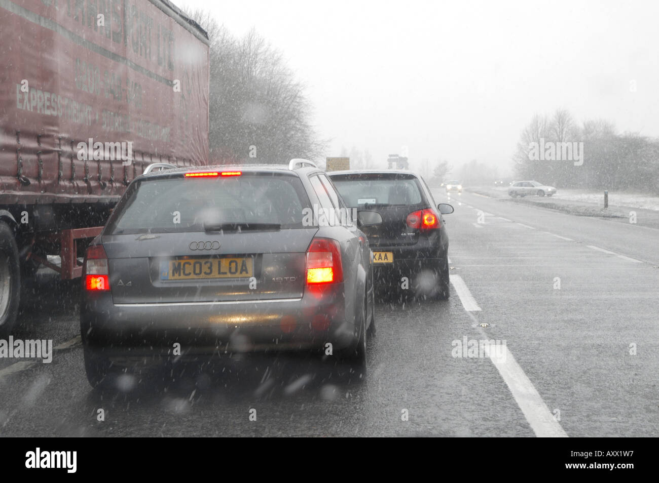 Drivers eye view of traffic driving slowly on the m1 motorway in wintry ...