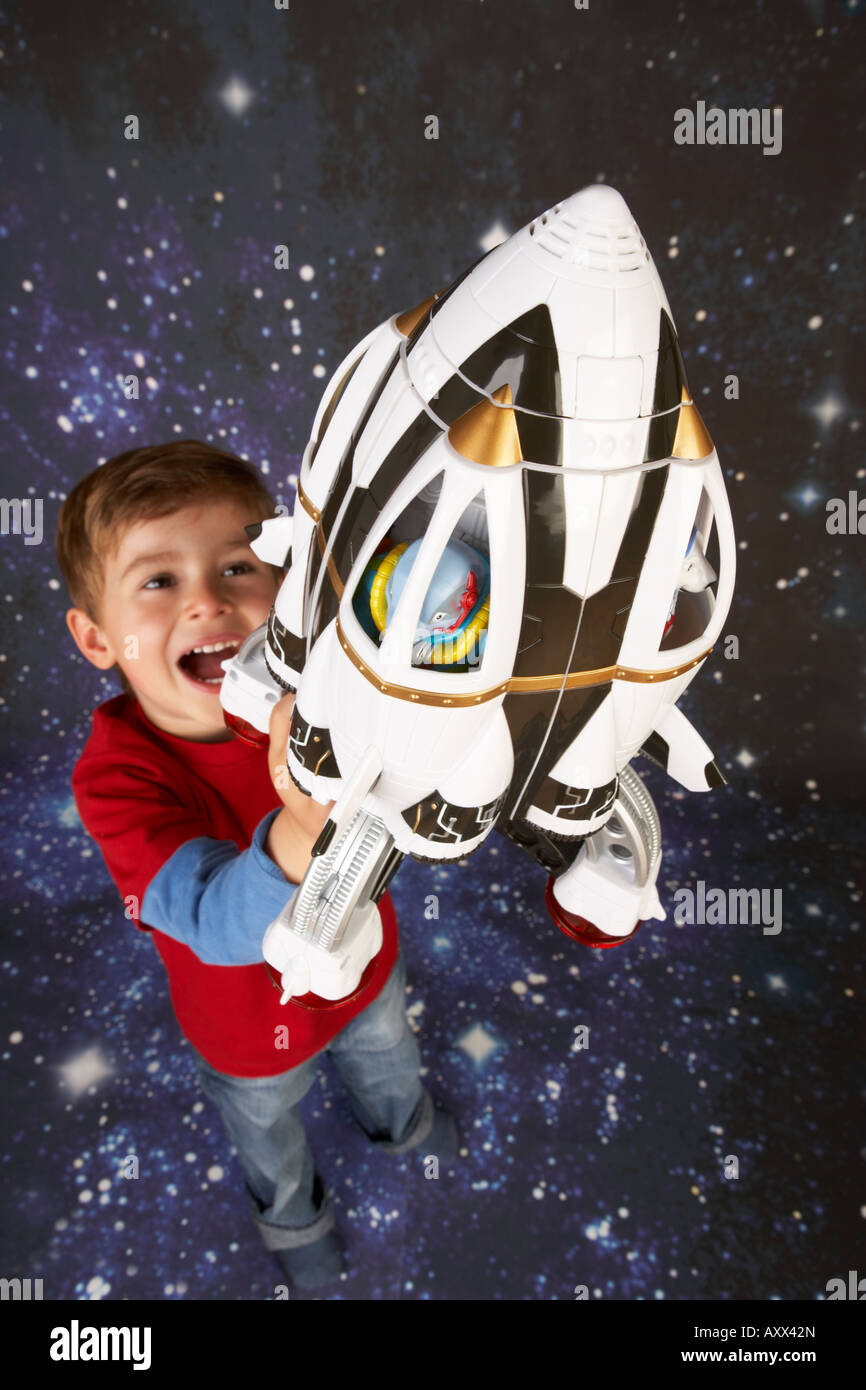 a boy plays with a flying spaceship rocket against a starry space ...
