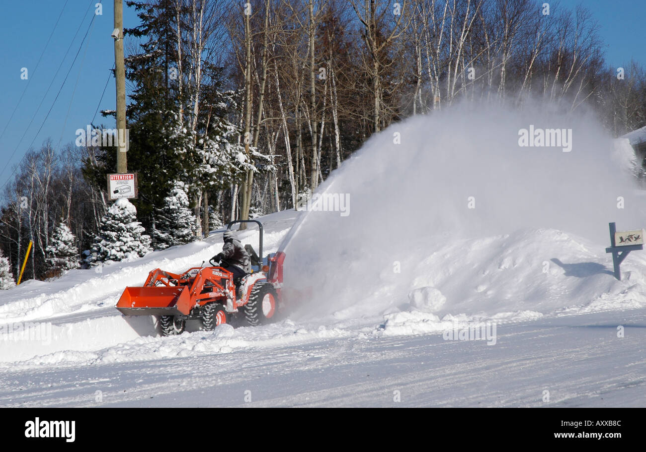 man snow blowing driveway after a winter storm in Eastern Canada near ...